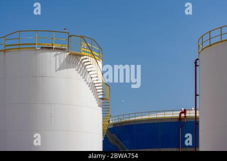 Industrial fuel storage tanks at marine terminal on coastline with ...