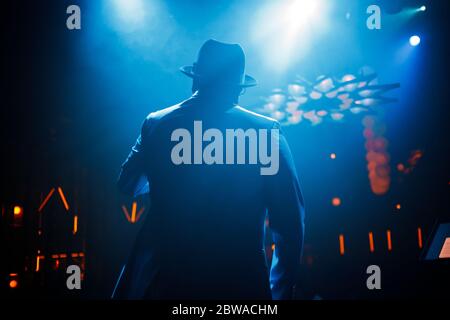 Dark-skinned singer in a suit and hat on a stage illuminated Stock ...