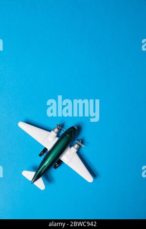 Flat lay of miniature toy airplane on blue background minimal trip and ...