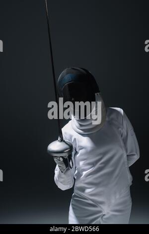Fencer in fencing mask holding rapier isolated on black Stock Photo - Alamy
