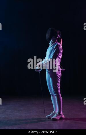 Side view of fencer holding rapier on black background with smoke Stock ...