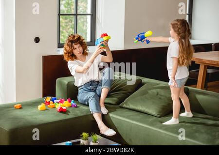 winking redhead girl with curly hair on blue background Stock Photo - Alamy