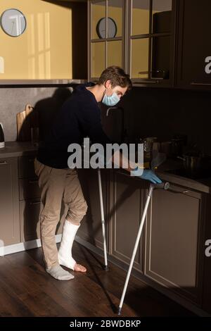 The young injured man cleaning the house Stock Photo - Alamy