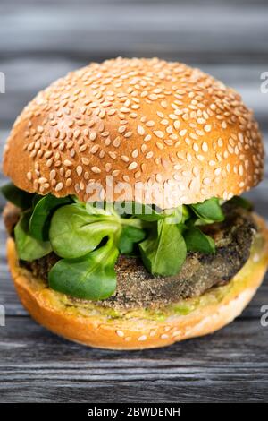 tasty vegan burger with microgreens served on wooden table with avocado ...