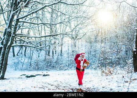 Portrait of excited Santa Claus covered in snow smiling at camera ...