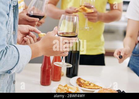 friends eating pizza and drinking red wine at home Stock Photo - Alamy