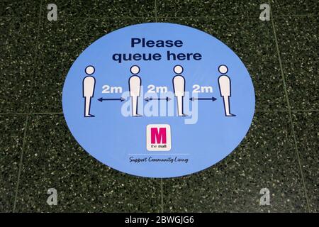 Please queue here sticker seen on the floor at a shopping mall in north ...