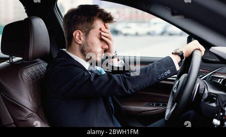 Stressed businessman driving alone in his new car Stock Photo - Alamy