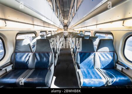 Interior of a Caltrain rail car; empty seats and aisle; Caltrain is a ...