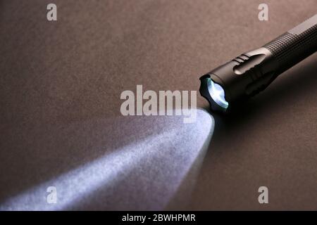 Glowing modern flashlight on dark background Stock Photo - Alamy