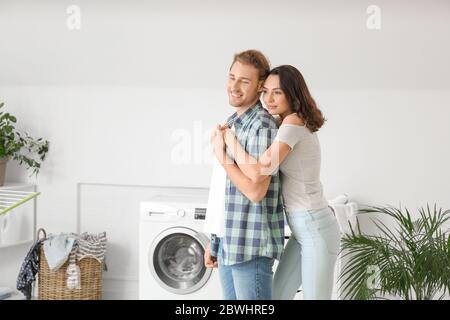 Happy young couple doing laundry at home Stock Photo - Alamy