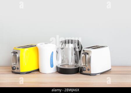 Different household appliances on table against beige background Stock ...
