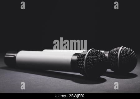 Modern microphones on dark background with fume Stock Photo - Alamy