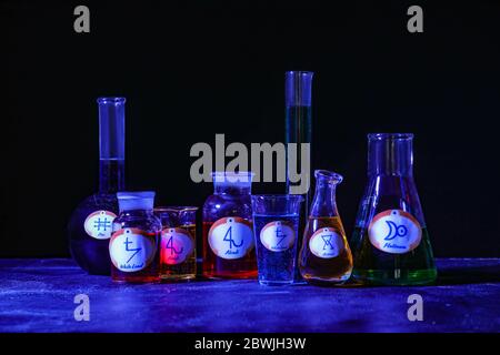 Potions with alchemical symbols on table Stock Photo - Alamy