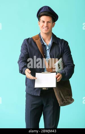 Handsome young postman on color background Stock Photo - Alamy