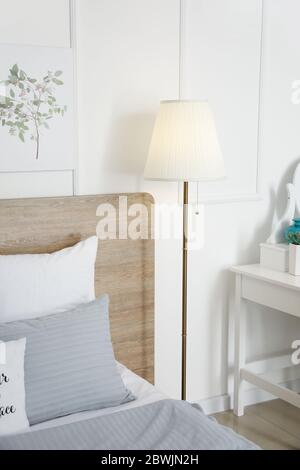 Lamp near bed in stylish room. Interior design Stock Photo - Alamy