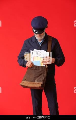 Handsome old postman on color background Stock Photo - Alamy