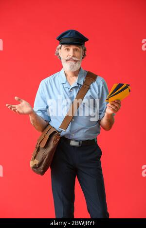 Handsome old postman on color background Stock Photo - Alamy