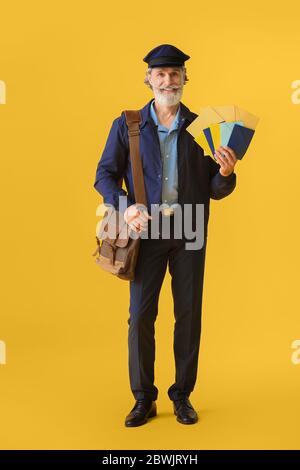 Handsome old postman on color background Stock Photo - Alamy