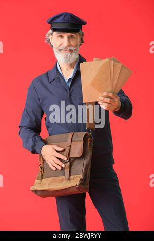 Handsome old postman on color background Stock Photo - Alamy