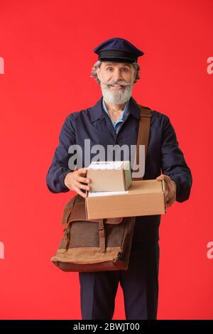 Handsome old postman on color background Stock Photo - Alamy