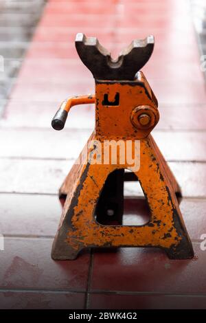 Detail view of a professional hydraulic lift arm supporting a car frame ...