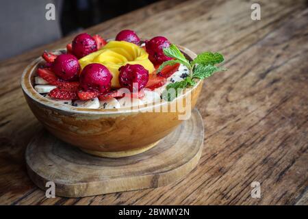 Yellow mango smoothie bowl decorated with granola, berries, fruit ...