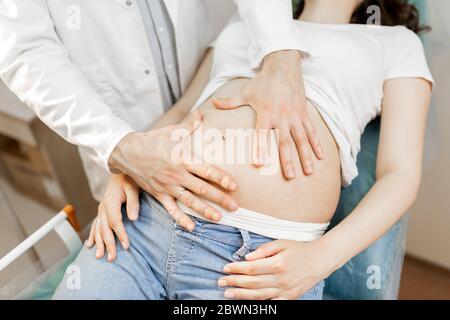 Doctor masseur makes a massage to a pregnant girl of the patient ...