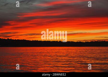 Beautiful red and orange sunset over the sea in a cloudy sky. The sun ...