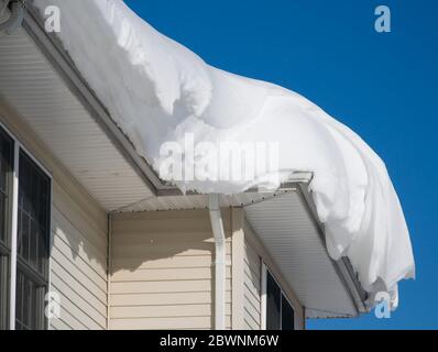 Snow drift on roof after two days of snowfalls. Thick layers hanging on ...