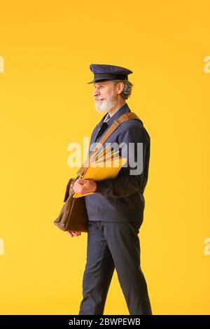 Handsome old postman on color background Stock Photo - Alamy