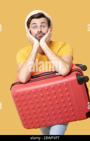 bearded man red suitcase yellow background vacation Stock Photo - Alamy