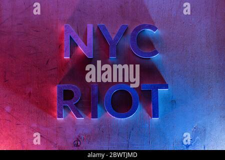 The words NYC chaos laid with metal letters on flat plywood surface ...