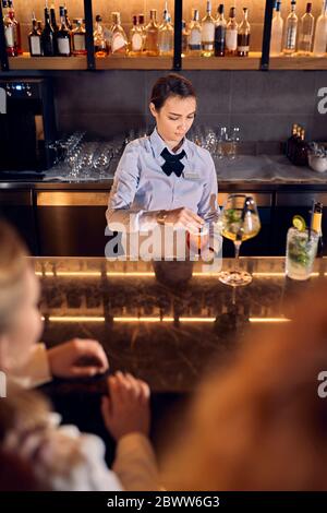 Barwoman preparing drinks in a bar Stock Photo - Alamy