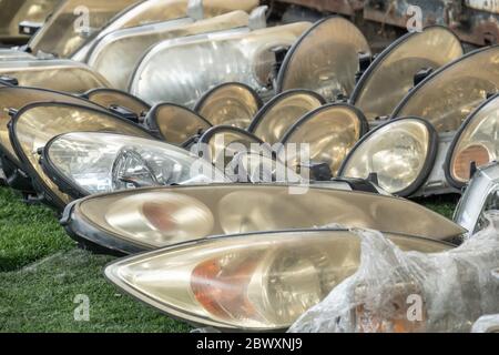 Used headlamp components for sale at scrapyard area Stock Photo - Alamy