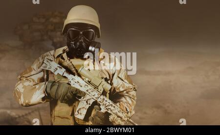 Soldier equipped with gas mask, helmet, rifle and carrying toxic gas ...