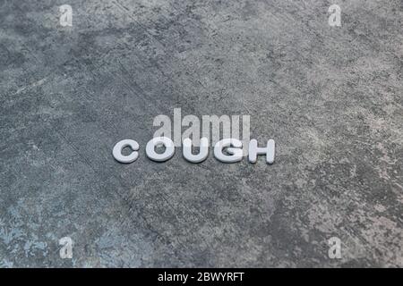 coughing written out on gray background with white lettering centered ...