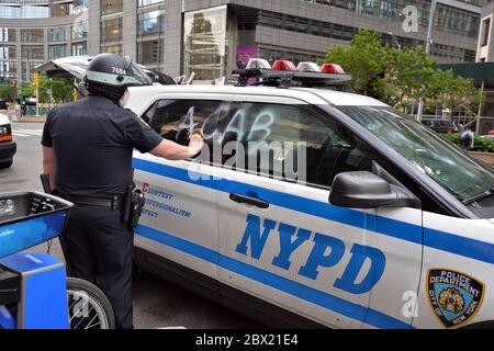 An NYPD officer wearing a riot gear helmet stands by in Times Square as ...