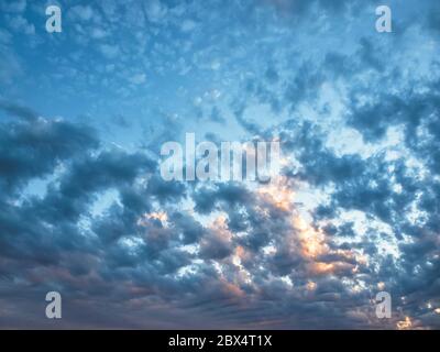 Multicolored clouds at sunset. Sunbeam Stock Photo - Alamy