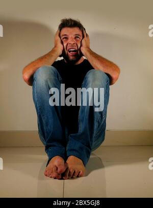 Unhappy male screaming alone at home with pain Stock Photo - Alamy