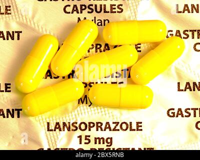 7 Lansoprazole yellow 15mg capsule pills against muted purple magenta ...