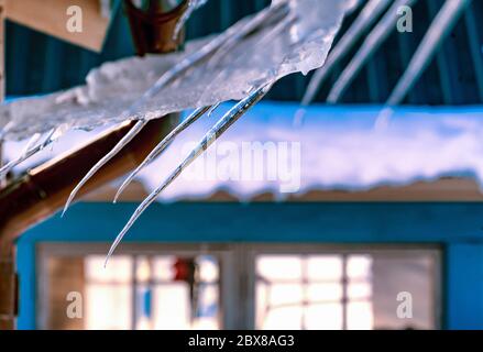 Photo of snow and bent icicles hanging from the roof of traditional ...