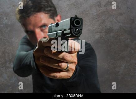 action portrait of serious and attractive hitman or special agent man ...