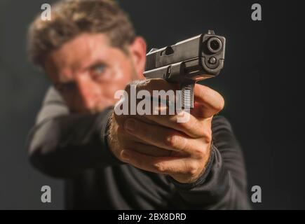action portrait of serious and attractive hitman or special agent man ...