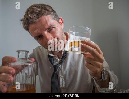 dramatic portrait of 30s to 40s drunk man in lose necktie drinking ...