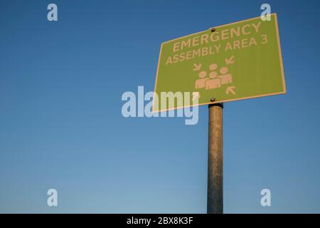 Emergency assembly area sign against blue sky Stock Photo - Alamy