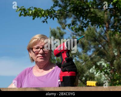 female worker with screwdriver working on insulated wall Stock Photo ...