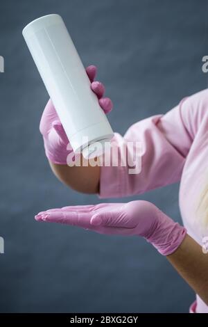 A person wearing a protective glove pours organic waste, including ...