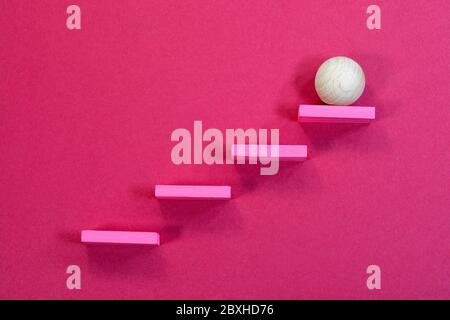 Leadership ball climbing the steps to the top Stock Photo - Alamy