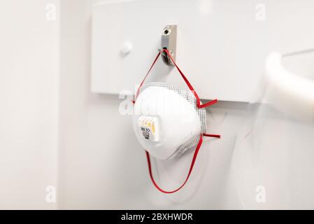 FFP3 face mask & visors hanging from hospital hook against white wall ...